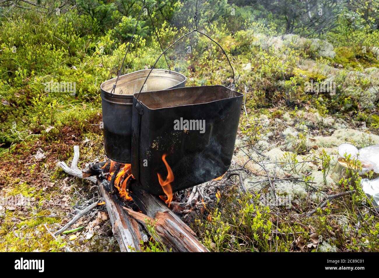 Cooking food in field conditions, in smoked cauldrons over a fire in a ...