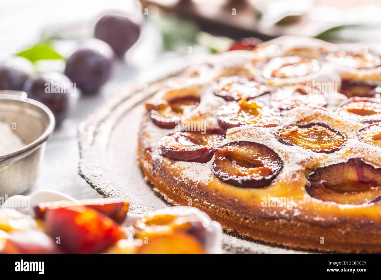 Homemade plum cake in vintage plate on wooden table. Plums pie with ...