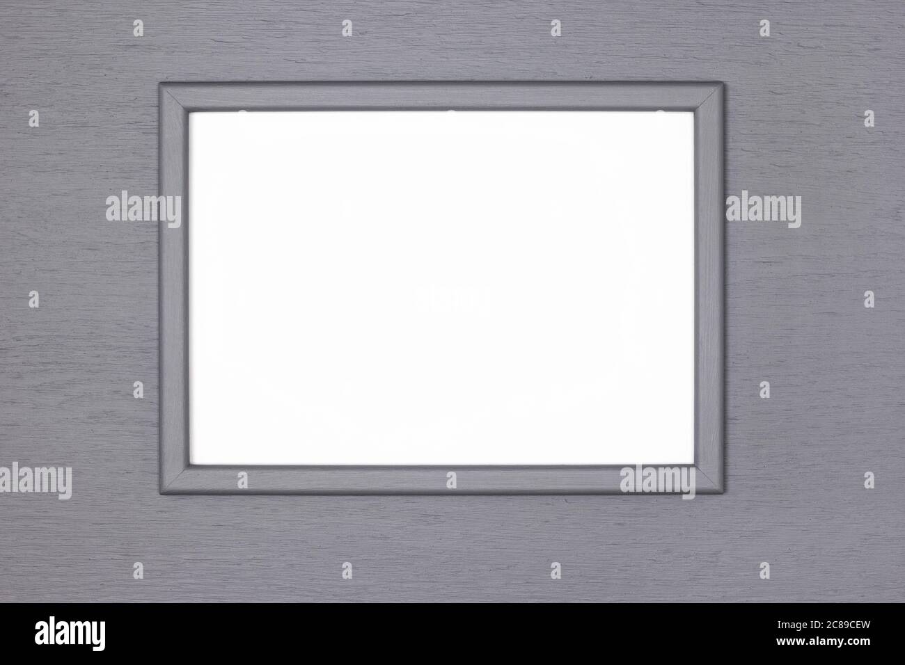 Gray wooden picture frame with blank white poster mock-up on grey ...