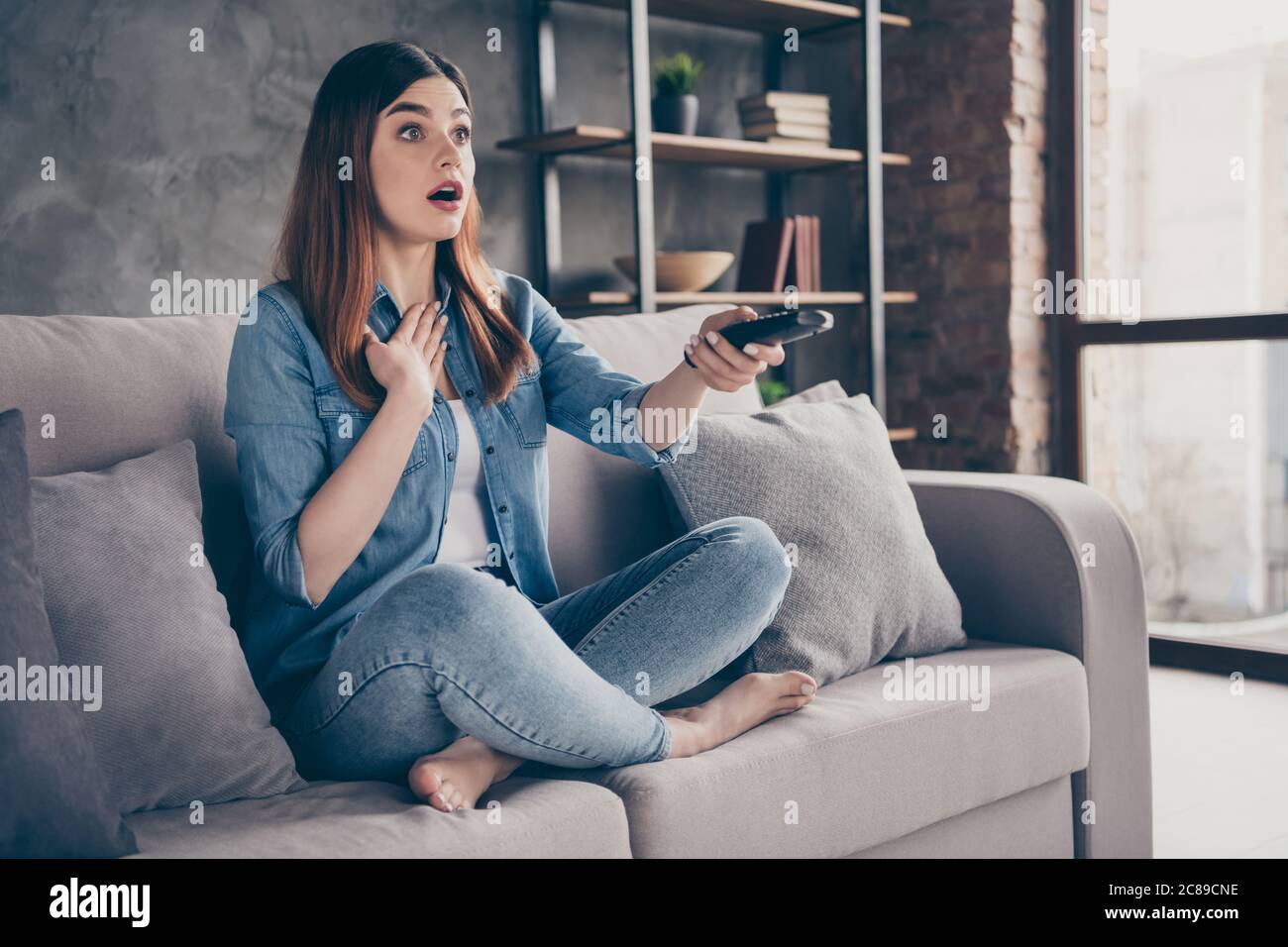 Frightened Girl Sit Divan Legs Crossed Hold Remote Control Watch Tv