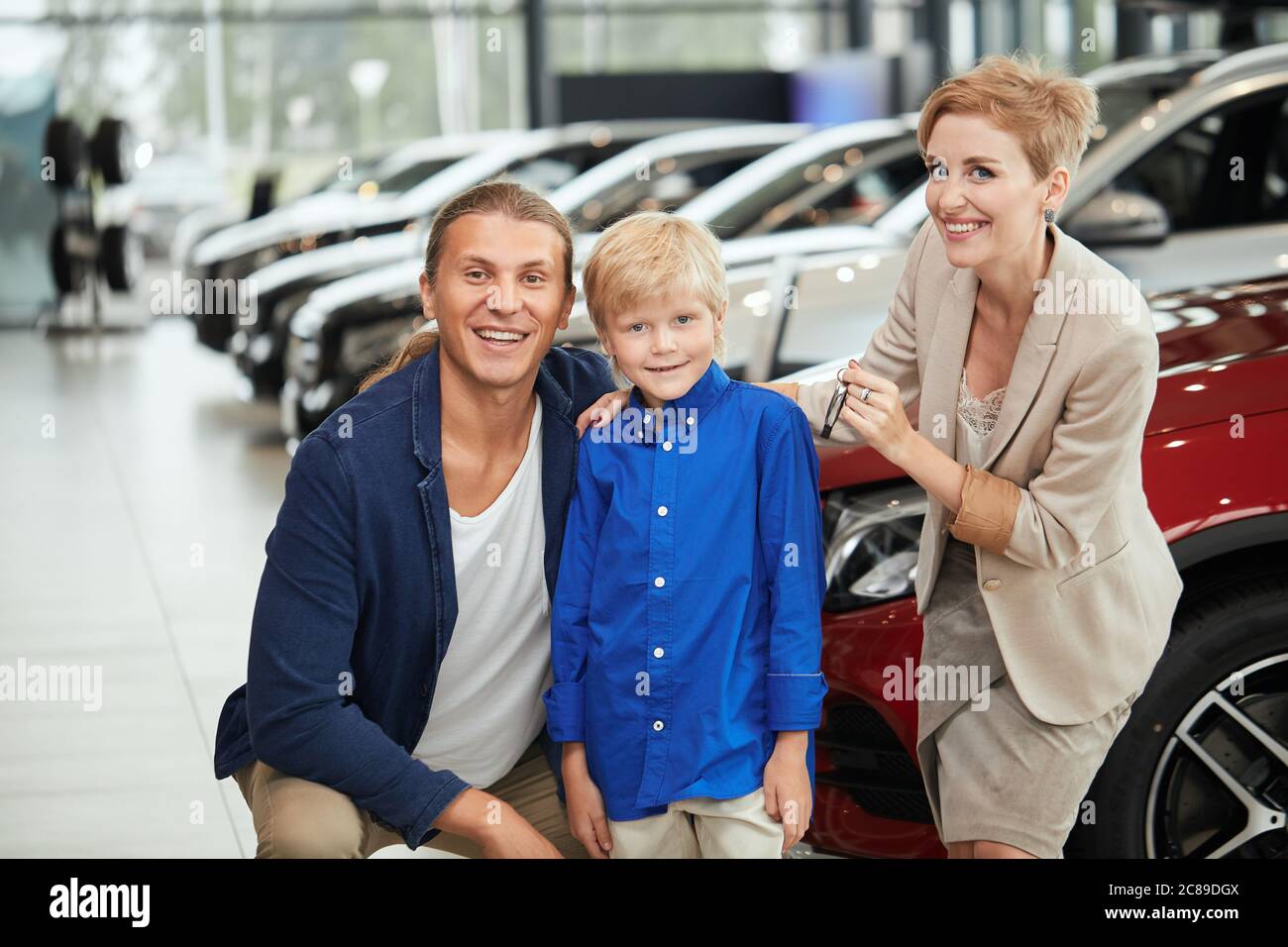 automobile sales centre. young family with child boy in car selling ...
