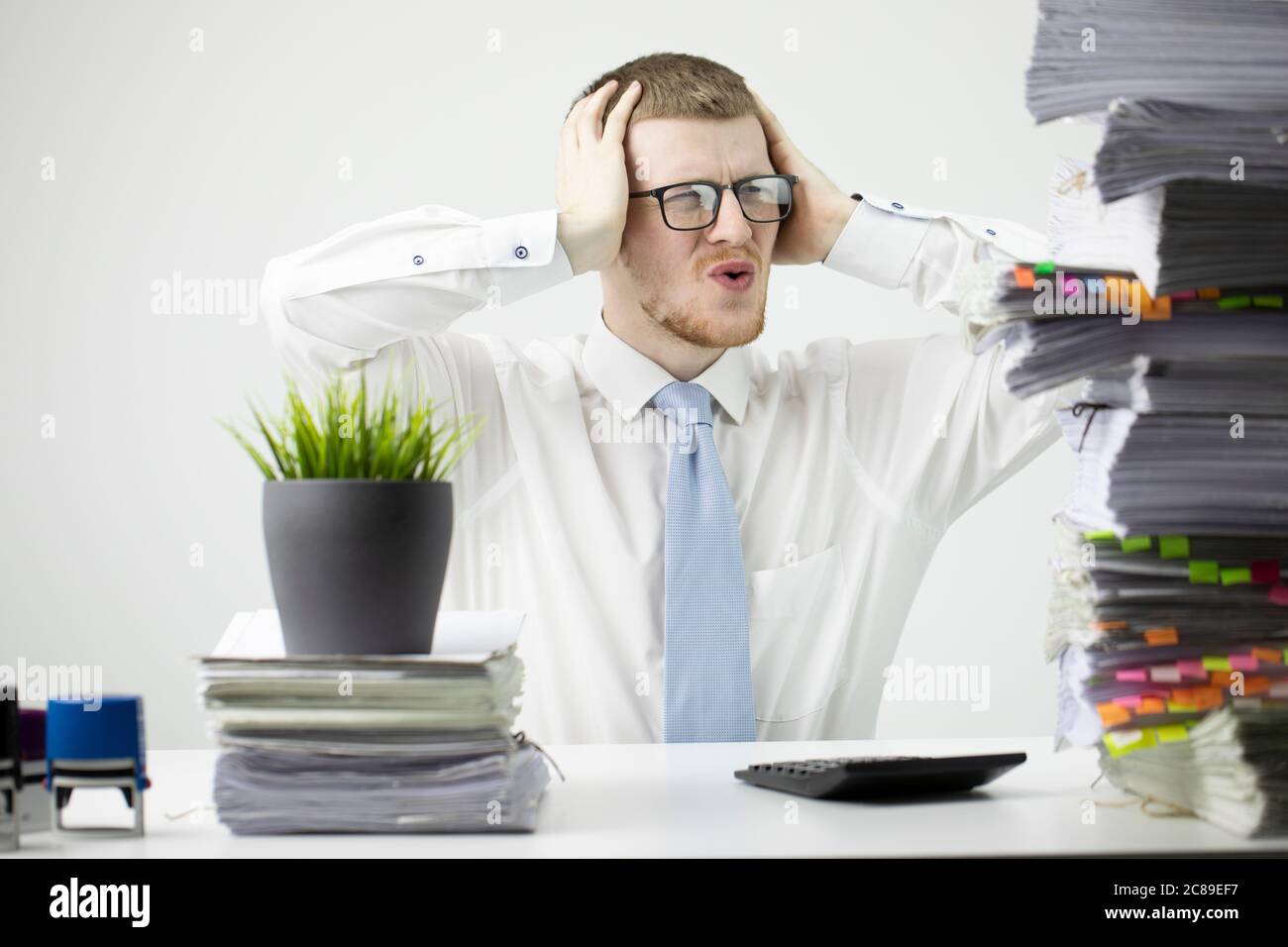 Portrait of an outraged surprised office worker in a white shirt with a ...