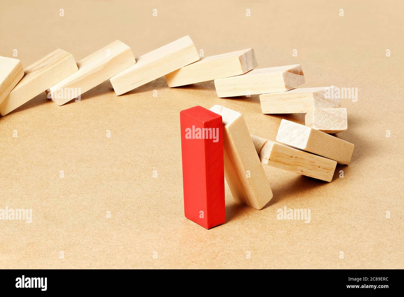red toy block refusing to fall, abstract leadership or different ...