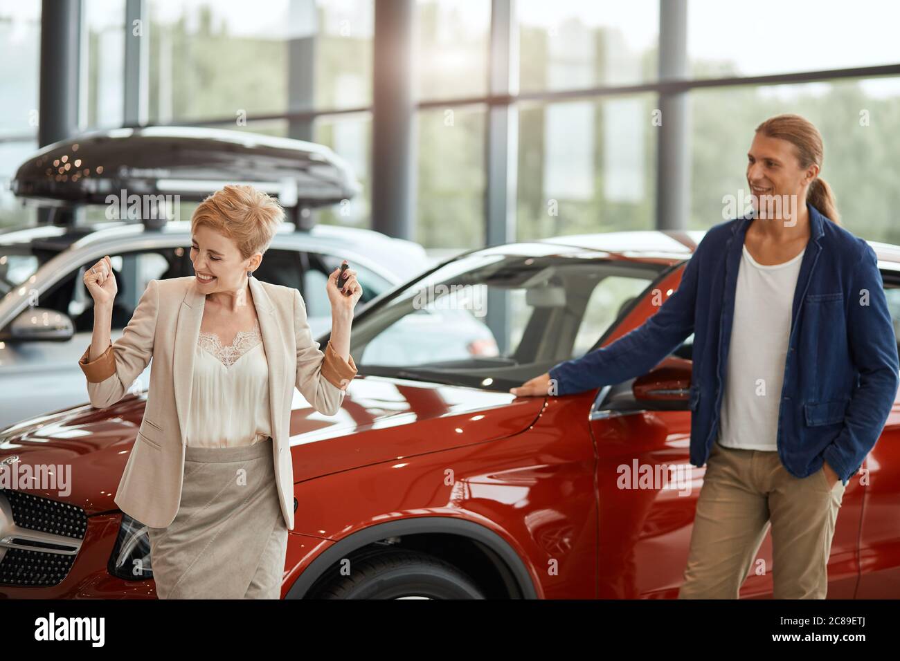 Female sales manager standing at the dealership telling about the ...