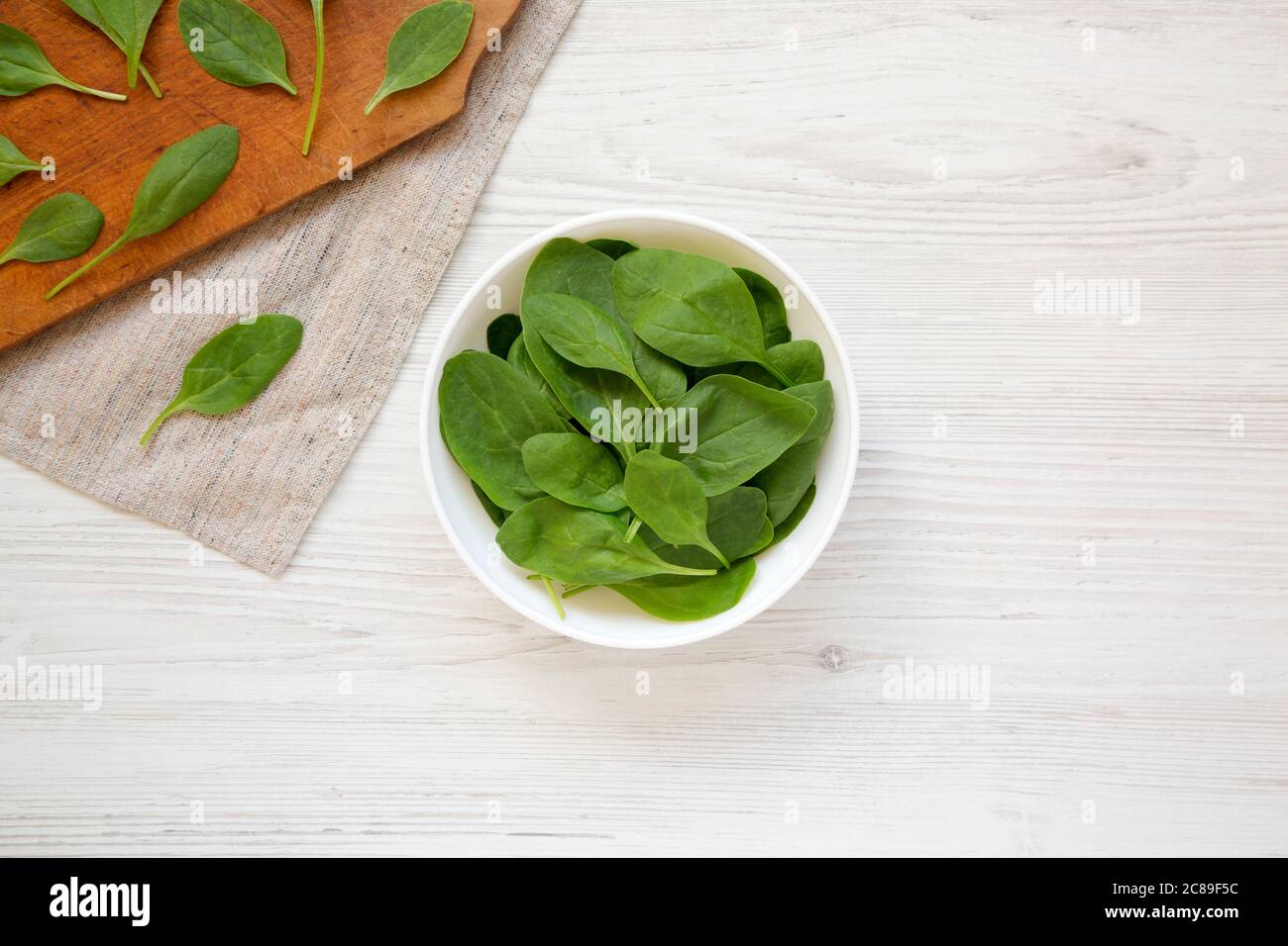 Fresh Baby Spinach in a white bowl, top view. Overhead, from above ...