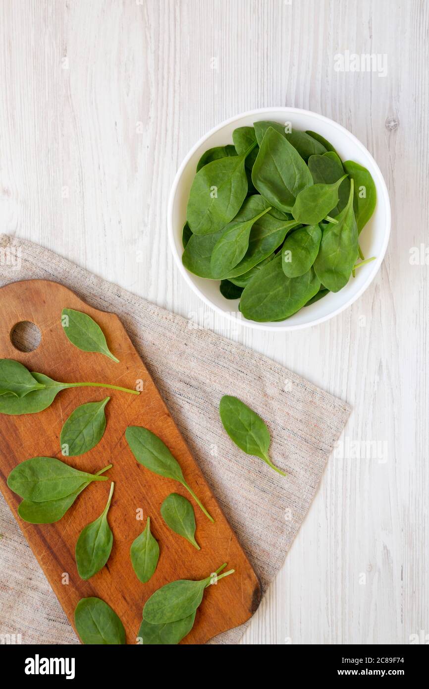 Fresh Baby Spinach in a white bowl, top view. Overhead, from above ...