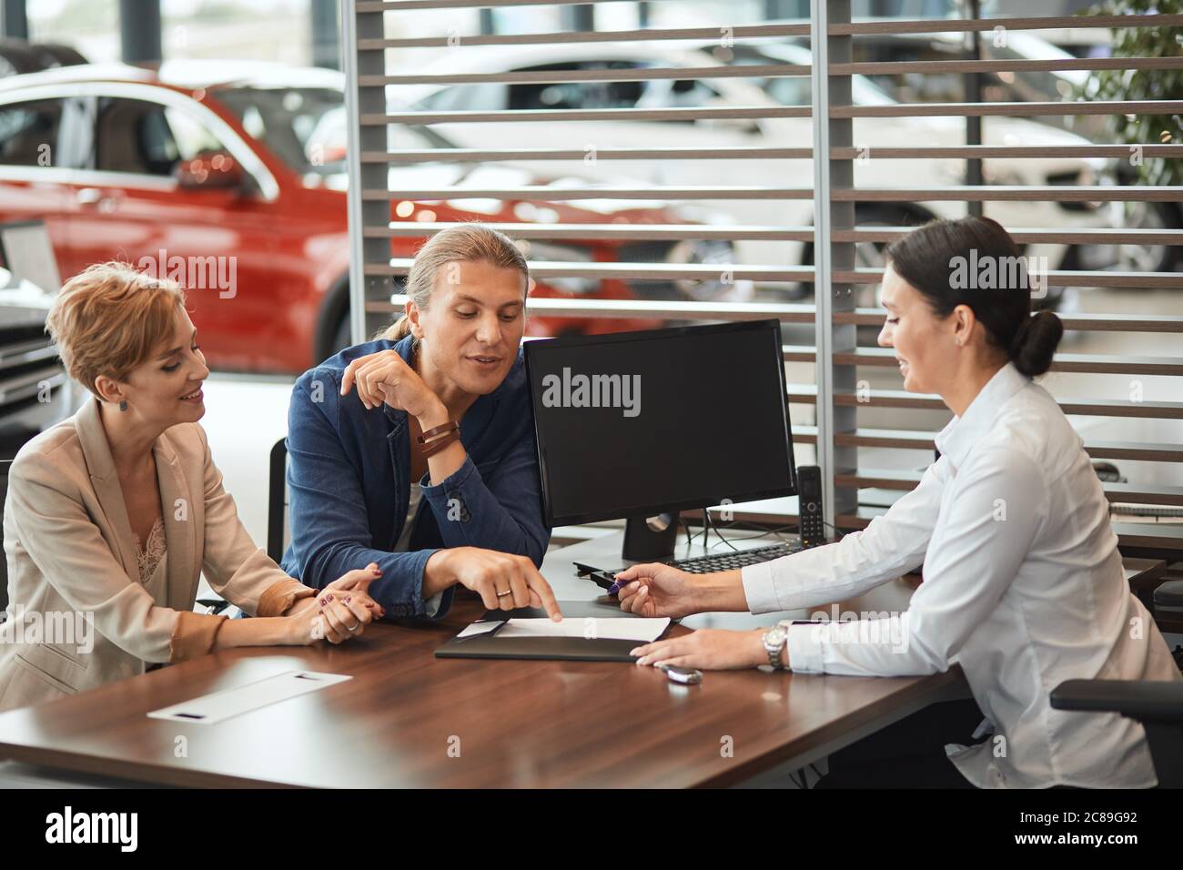 Signing papers at dealership hi-res stock photography and images - Alamy