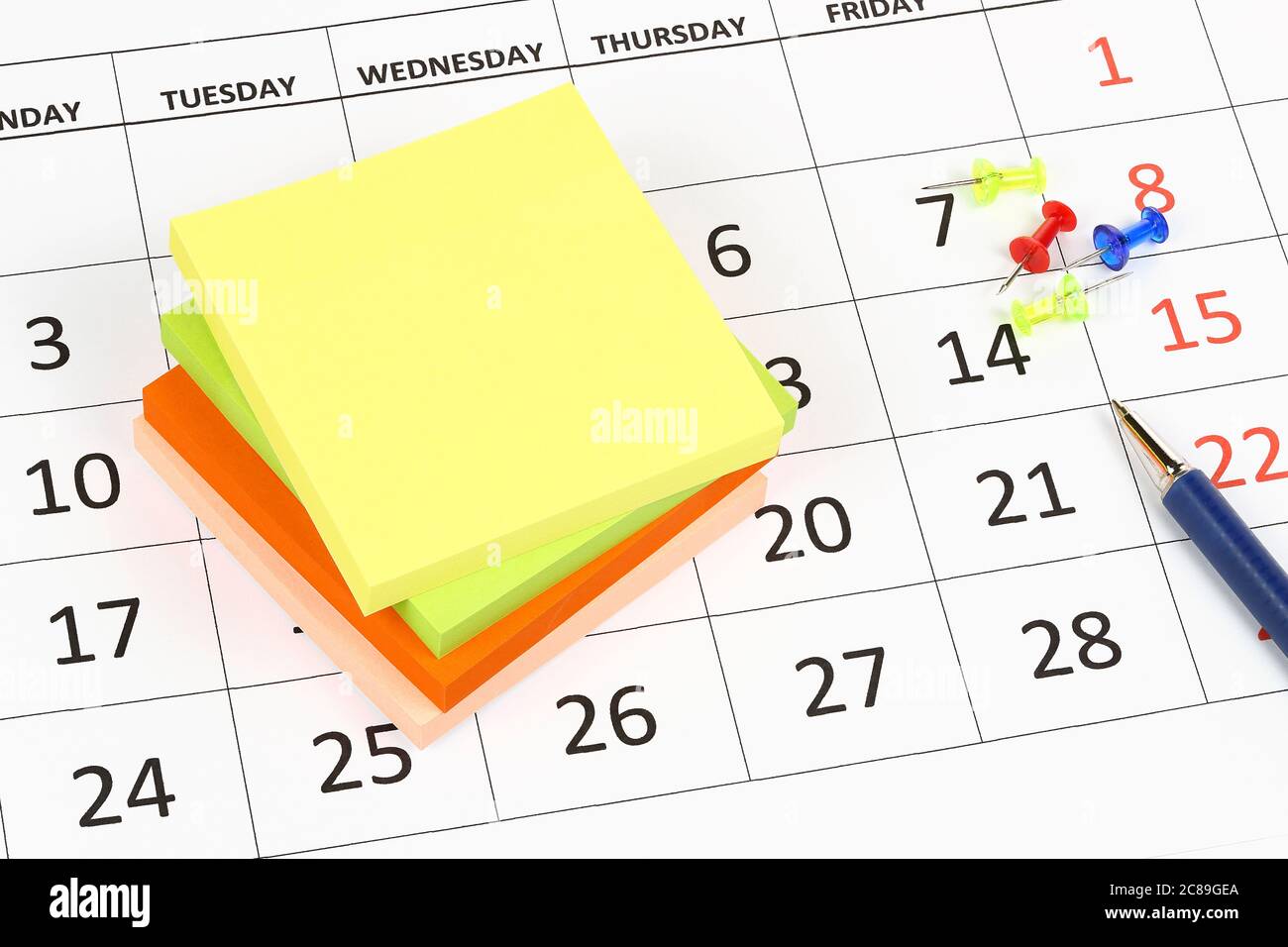 adhesive notes with pins and pen on calendar Stock Photo - Alamy