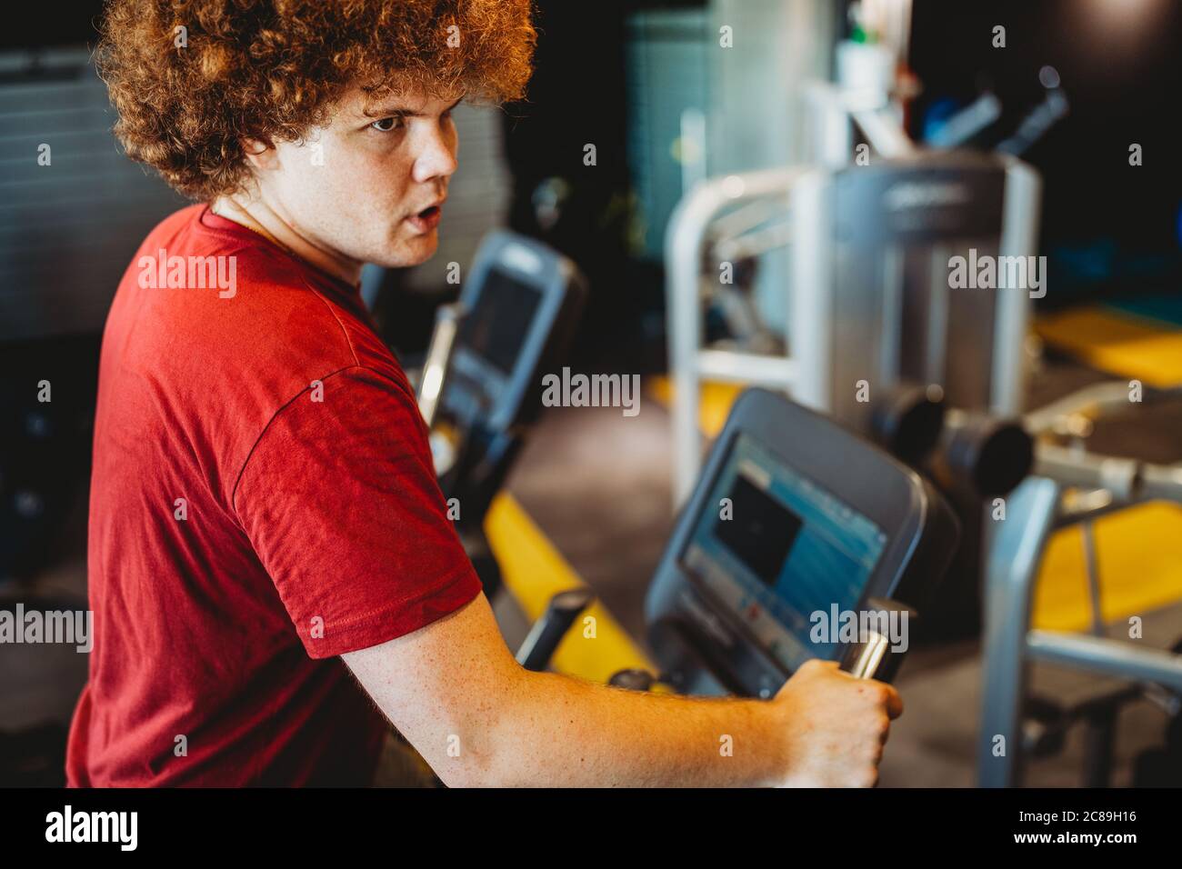 Overweight young man exercising in gym to achieve goals Stock Photo - Alamy