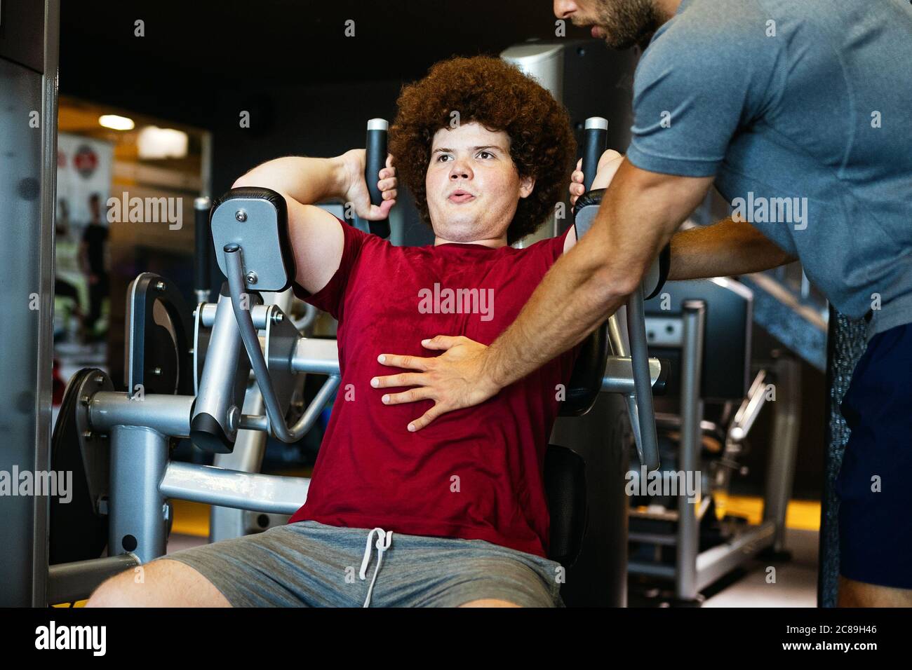 Fat young men with trainer exercising at fitness gym Stock Photo - Alamy