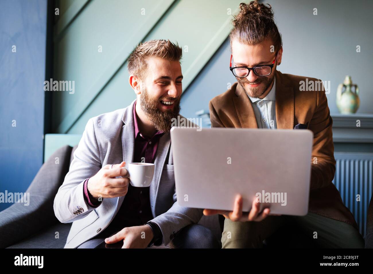 Group of attractive young business men colleagues working together in ...