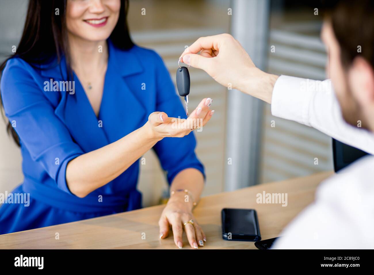 Attractive european business lady receiving car keys from car sales ...