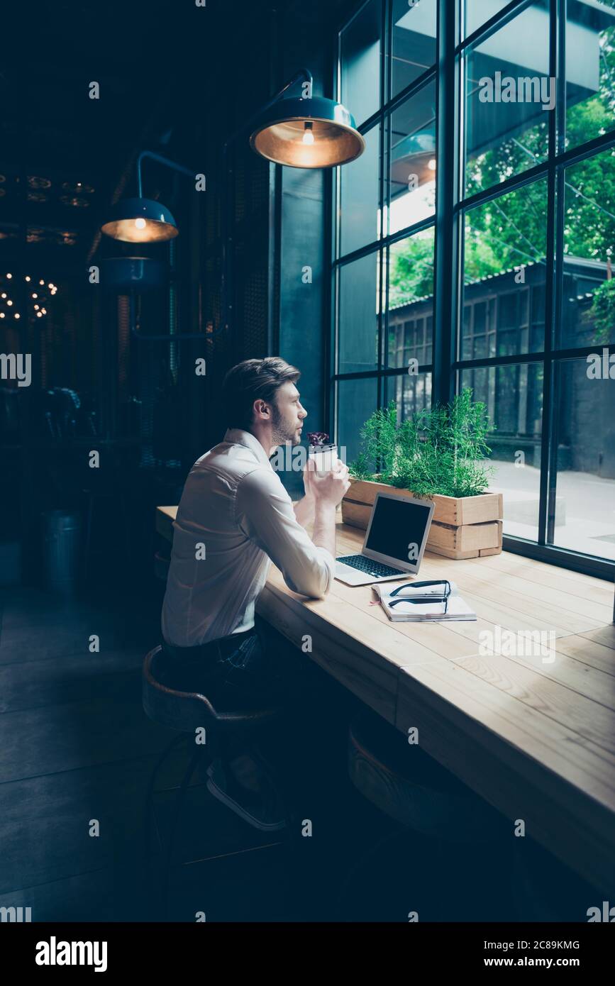 Back view of an entrepreneur, sitting in the dark modern restaurant ...