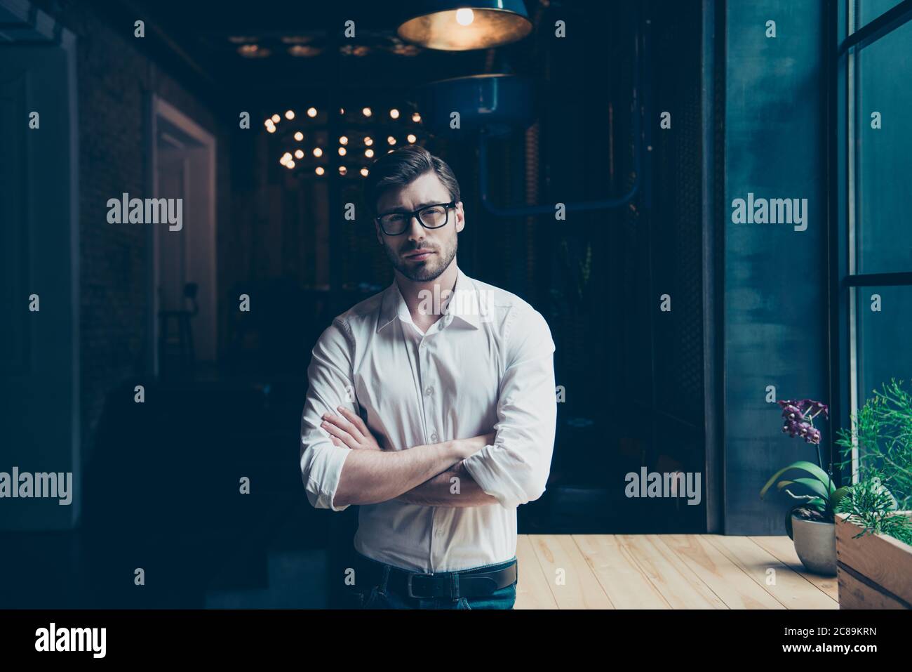 Young attractive successful ceo is standing at his work station in a ...
