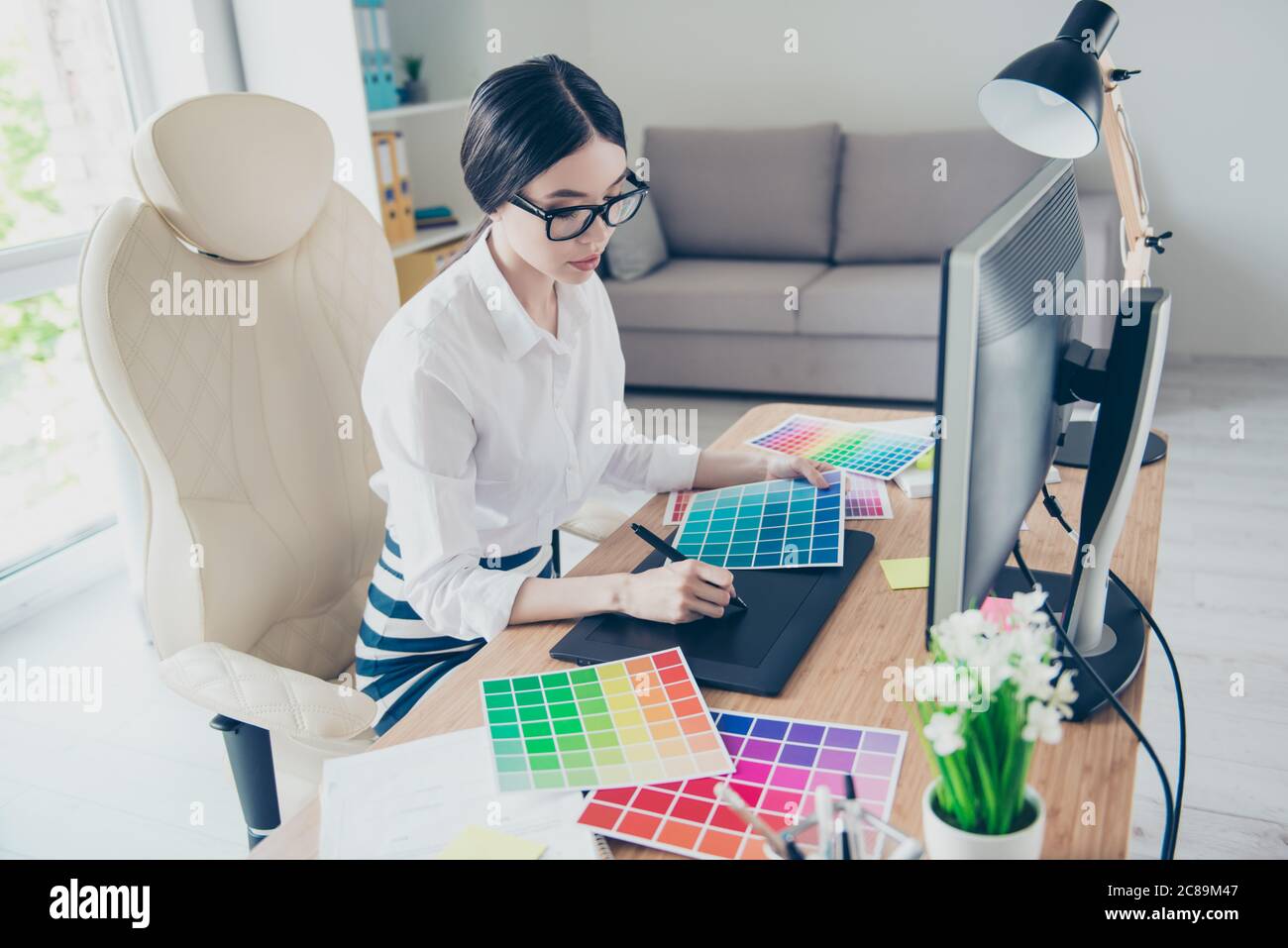 Busy young asian graphic designer is drawing something on graphic ...