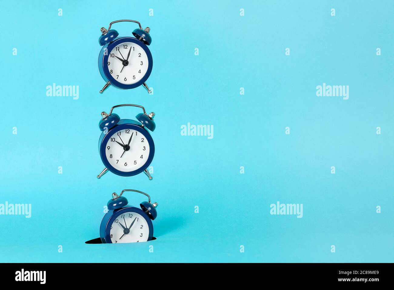 alarm clock falling into hole, abstract time concept Stock Photo - Alamy