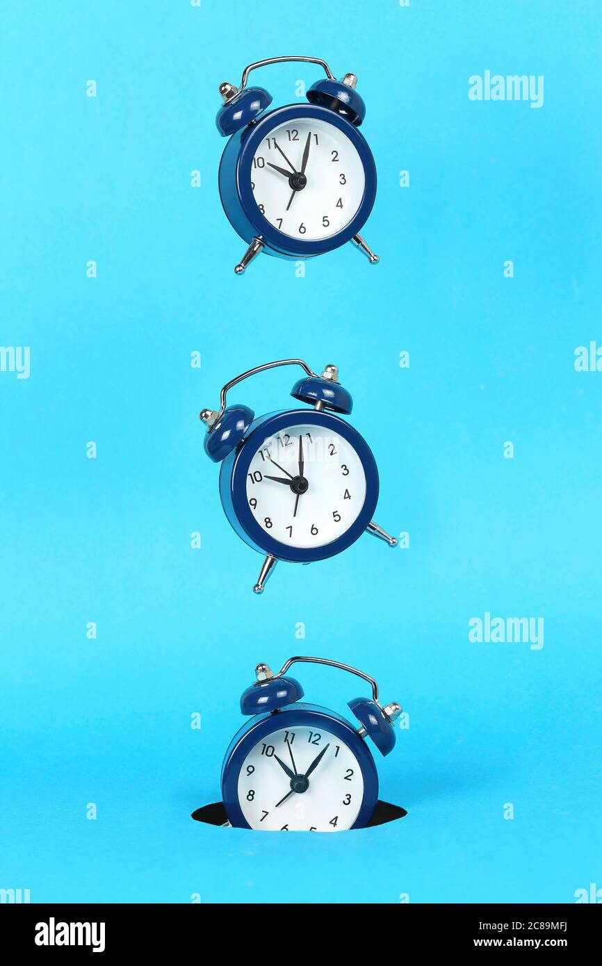 alarm clock falling into hole, abstract time concept Stock Photo - Alamy