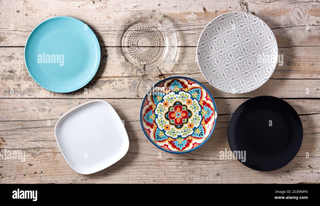 Set of different empty plates on wooden background Stock Photo - Alamy