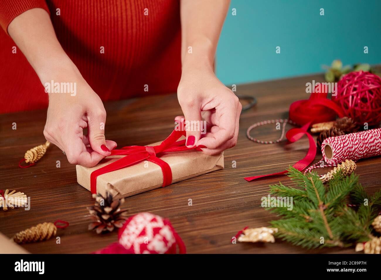 Female hands tying knot on giftbox and different Christmas symbols ...
