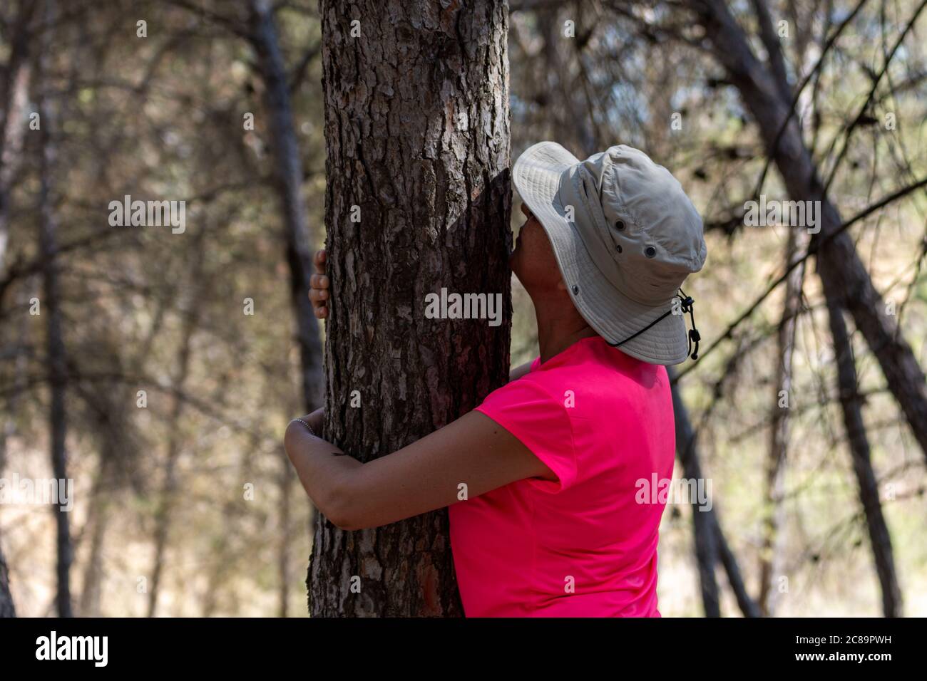 Woman hugging tree in forest hi-res stock photography and images - Alamy
