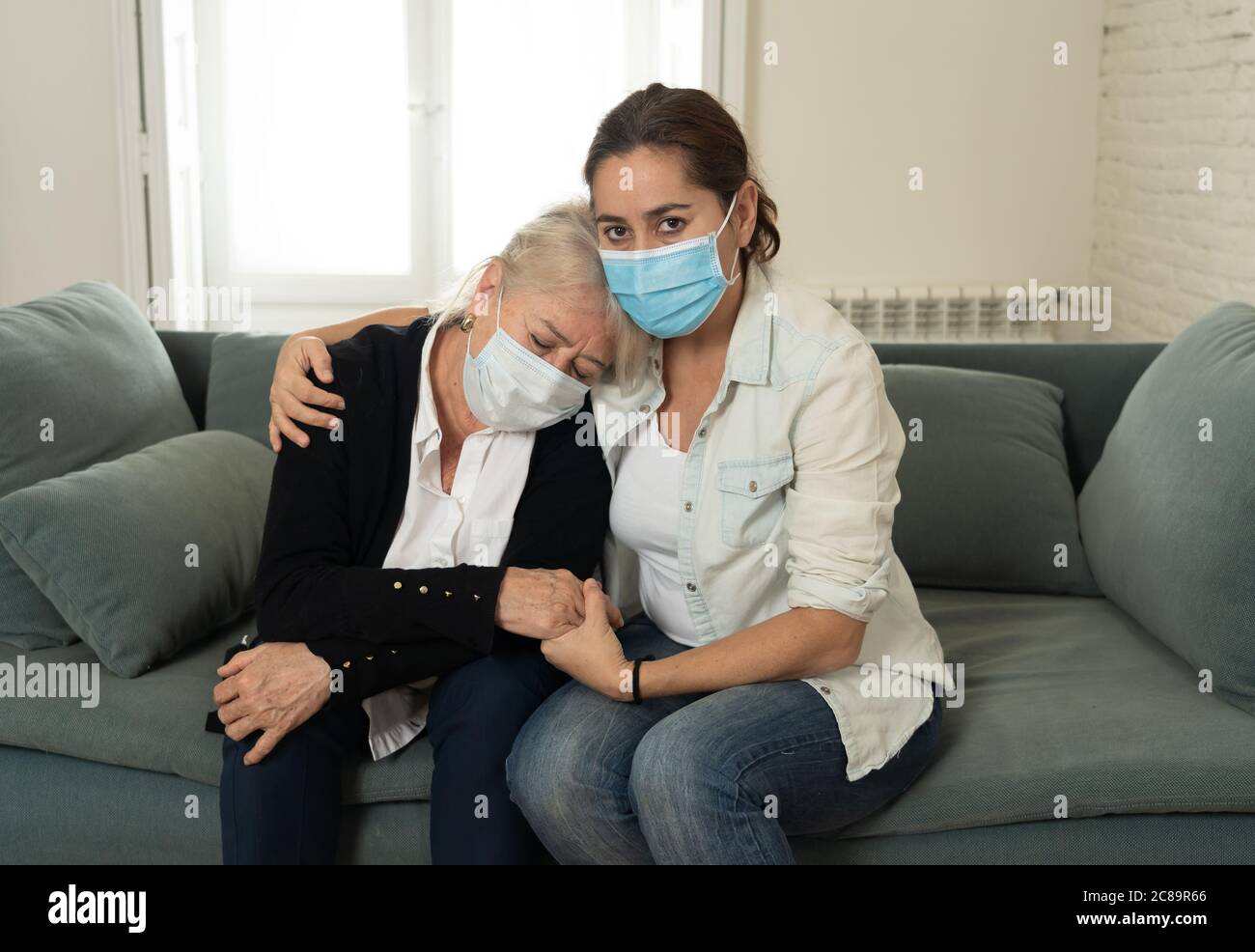 Depressed senior mother and daughter wearing medical mask crying and ...