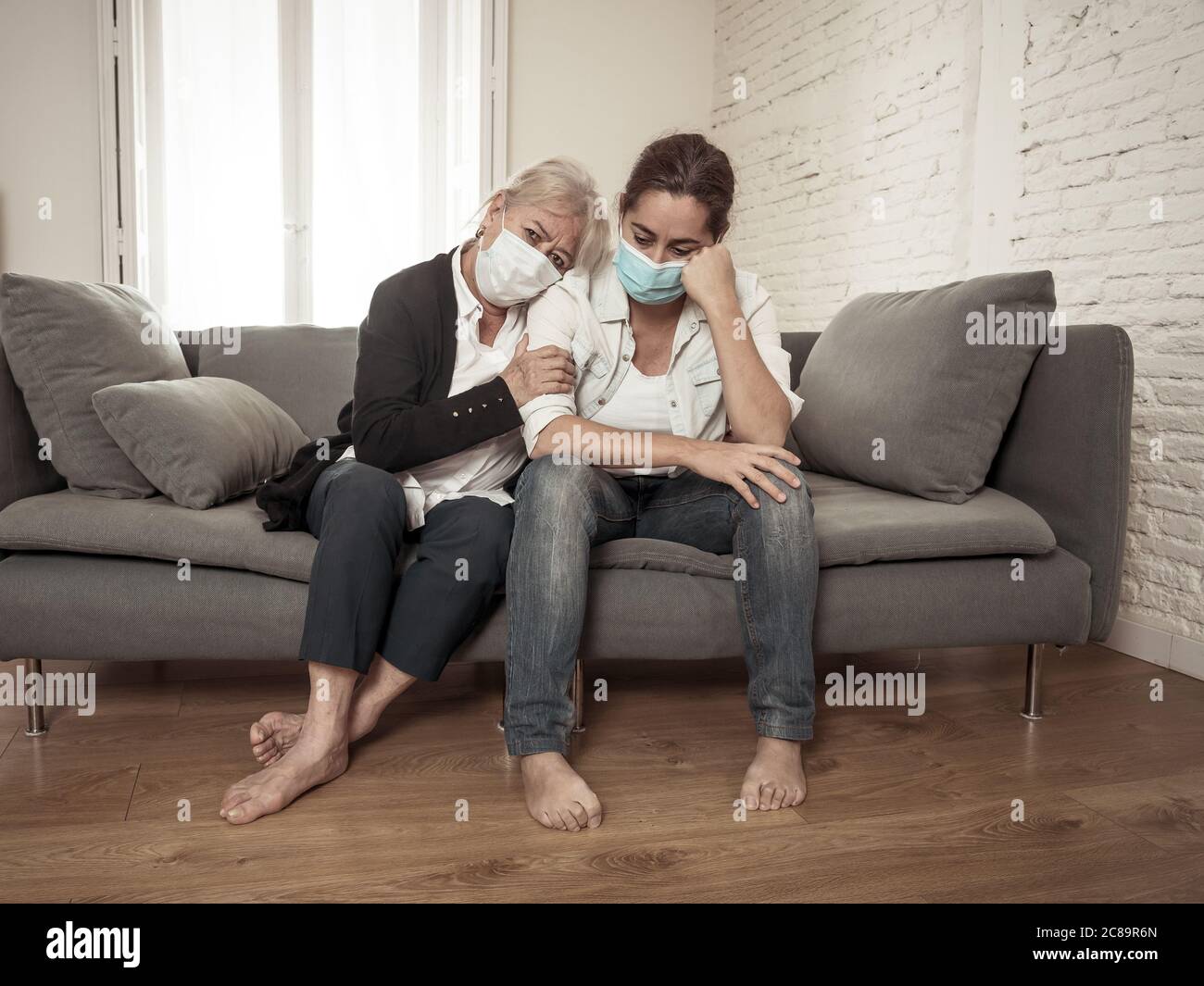Depressed senior mother and daughter wearing medical mask crying and ...