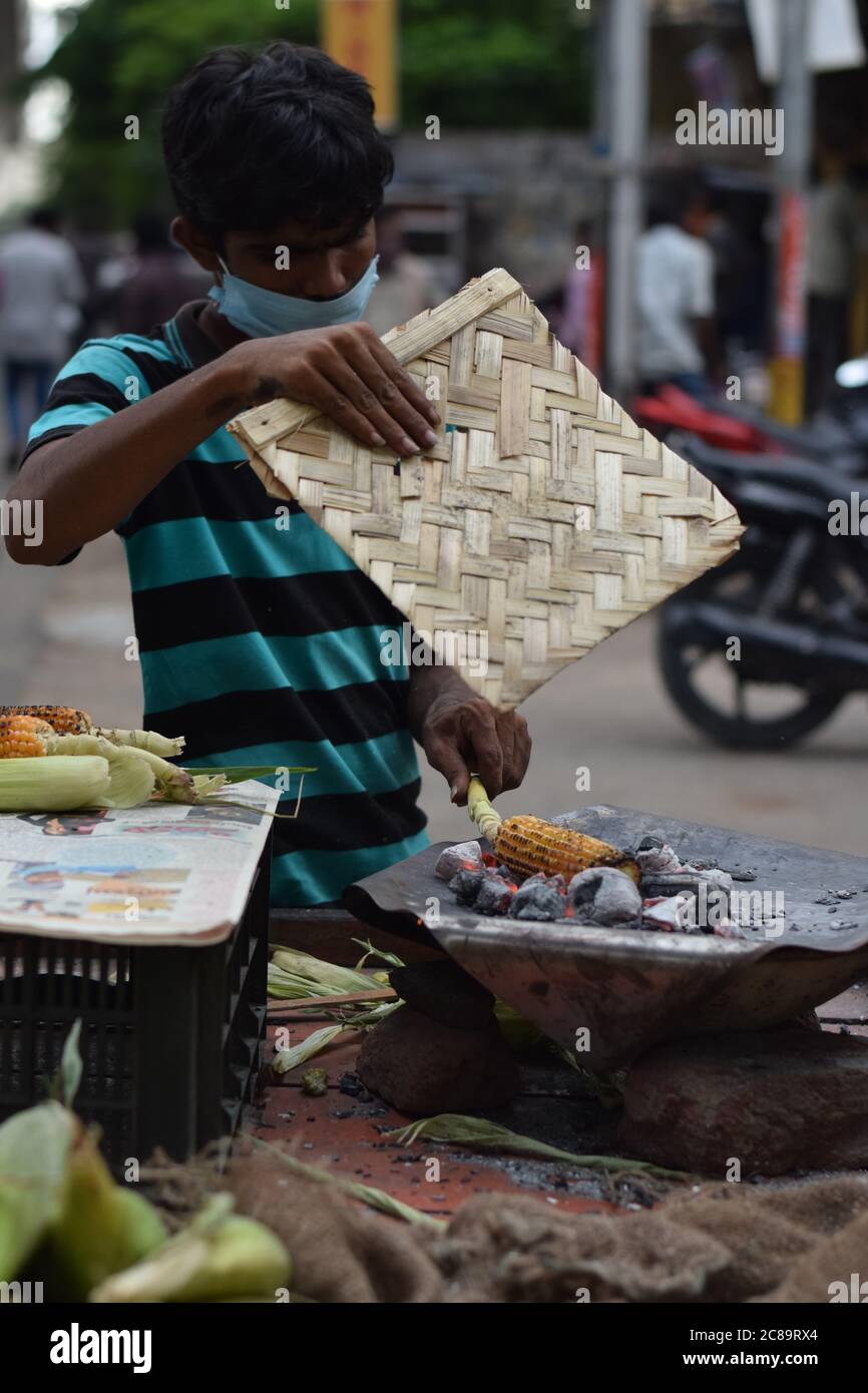 Hyderabad, Telangana, India. july-20-2020: Roasted corn, people are ...