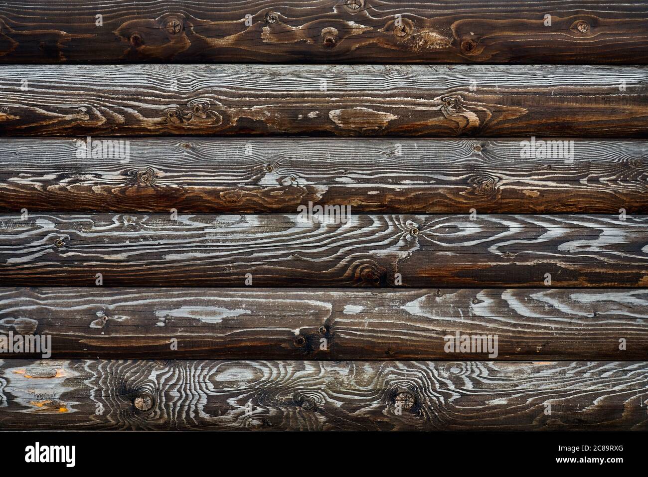 Brown aged volume rough rustic pallets on house wall outdoors, dark ...