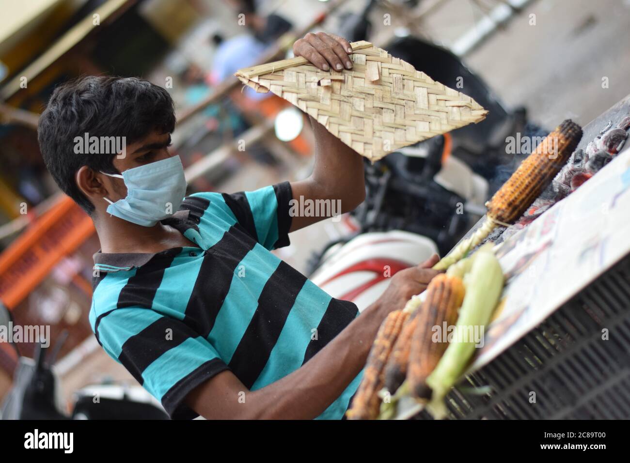 Hyderabad, Telangana, India. july-20-2020: Roasted corn, people are ...