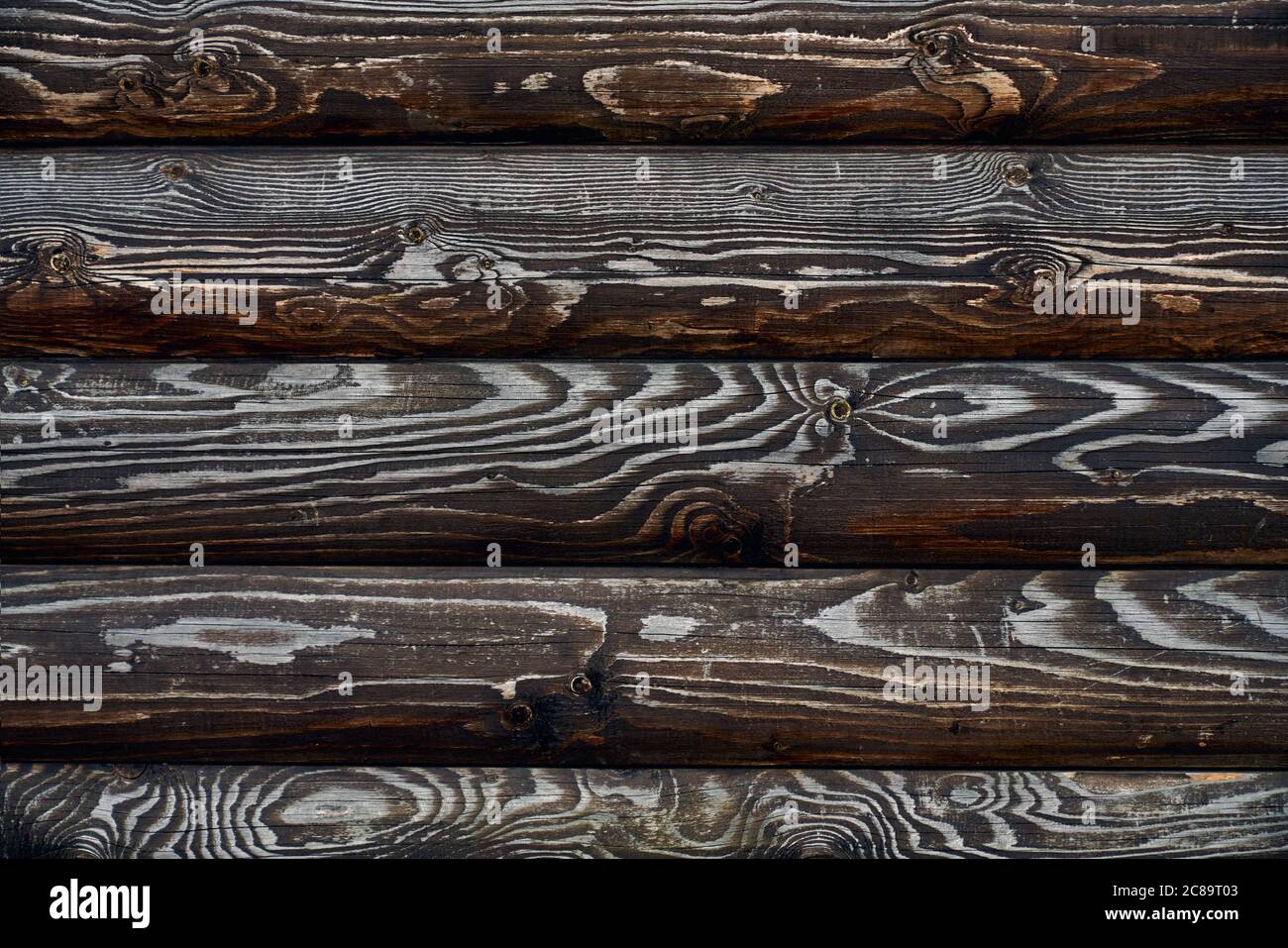 Brown aged volume rough rustic pallets on house wall outdoors, dark ...