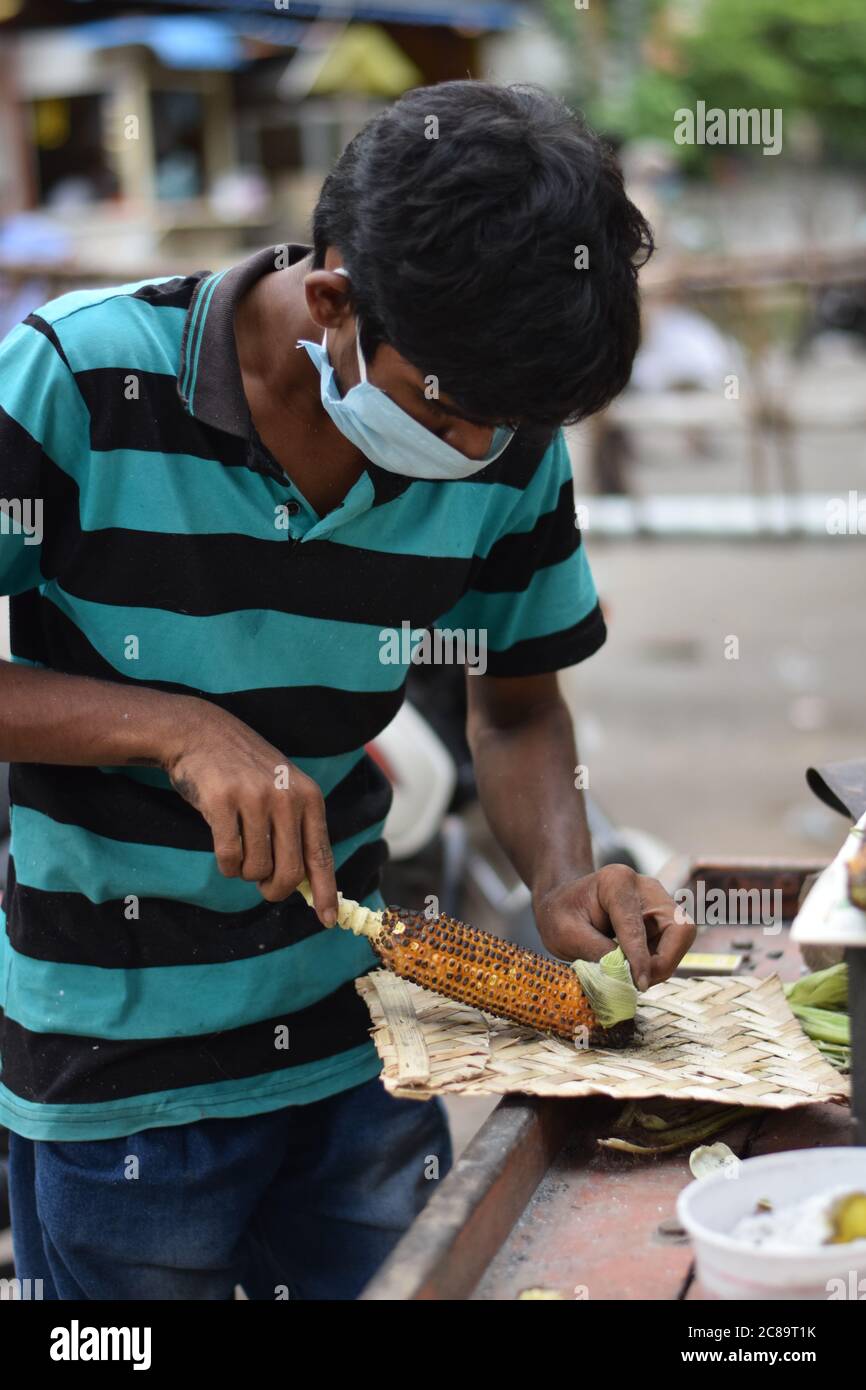 Hyderabad, Telangana, India. july-20-2020: Roasted corn, people are ...