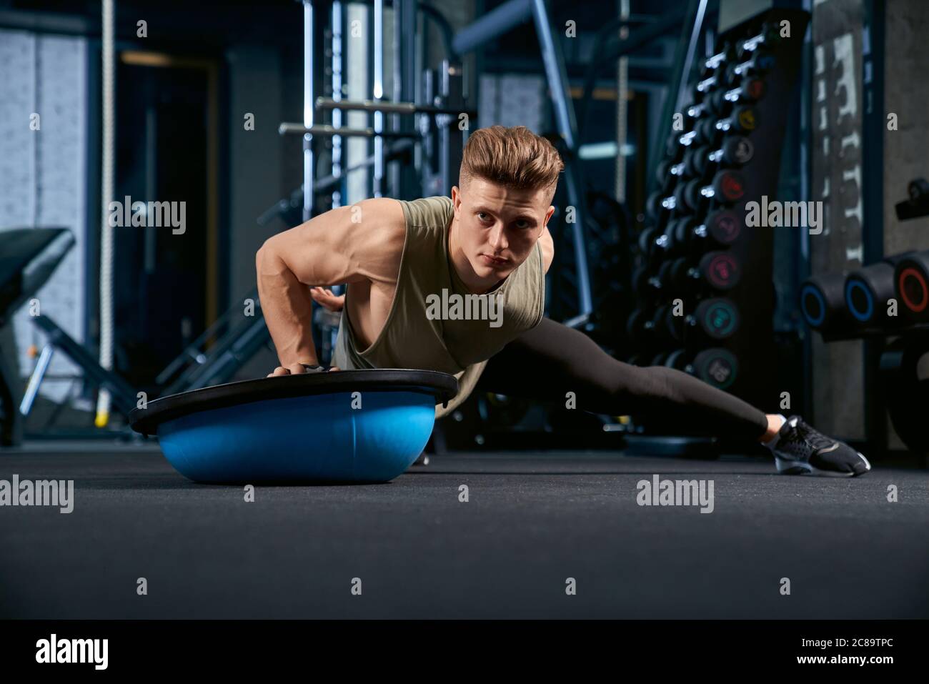 Front view of muscular caucasian man training on floor using balance ...