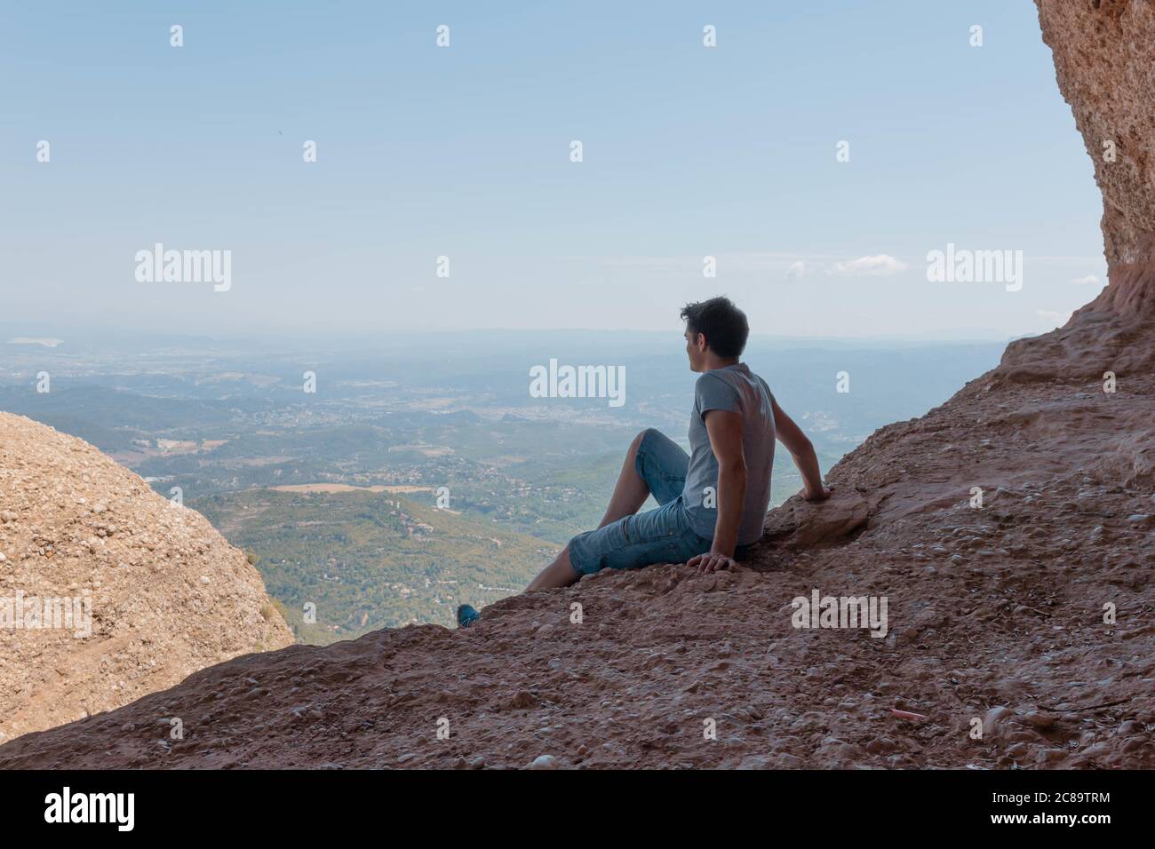 Side view of a young male wearing a gray shirt and jeans shorts Stock ...
