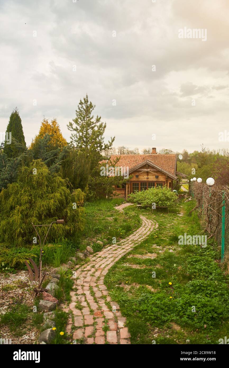 Brick winding path to a wooden house Stock Photo - Alamy