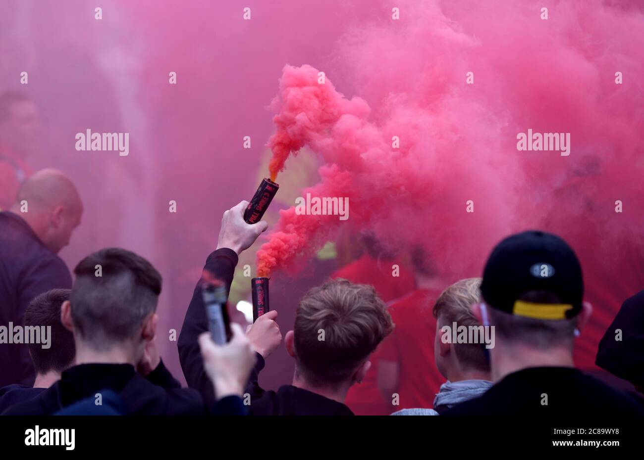 Liverpool fans set of flares outside Anfield as the team bus arrives ...