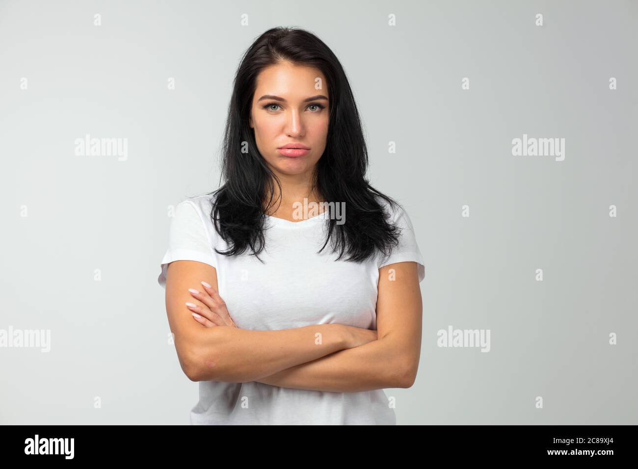 disappointed woman standing with arms crossed and expressing resentment ...