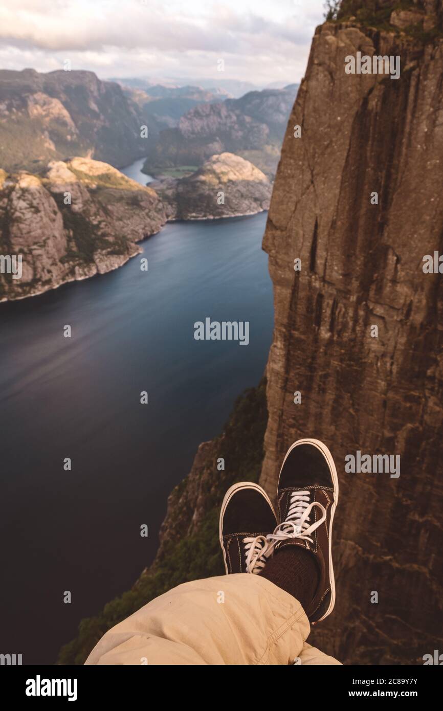 Person cross legged at edge of cliff with a fjords view in Norway Stock ...