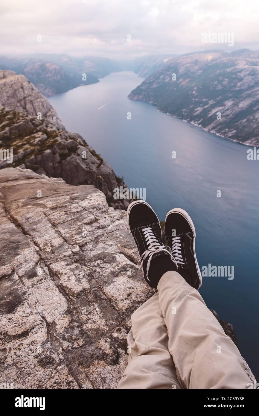 Person cross legged at edge of cliff with a fjords view in Norway Stock ...