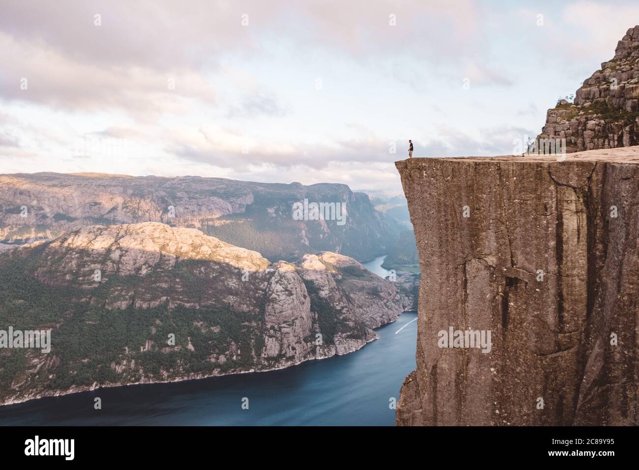 Man standing at edge of cliff at Preikestolen, Norway Stock Photo - Alamy