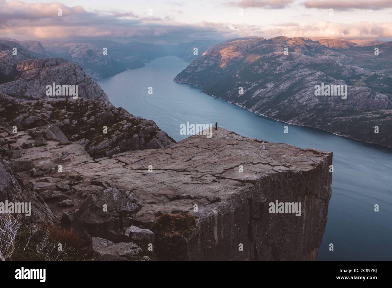 Unrecognizable man standing at cliff at Preikestolen, Norway Stock ...
