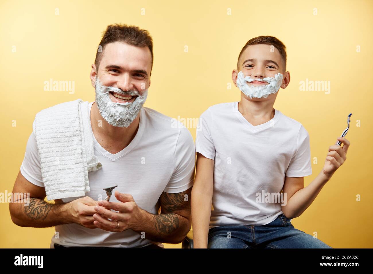 bearded Father and son shaving on yellow background Stock Photo - Alamy