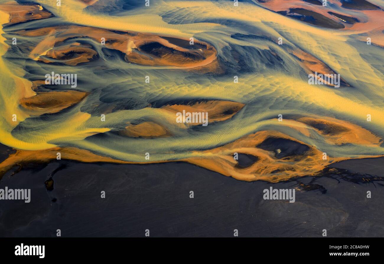 Colorful glacier rivers on the south coast of Iceland with black sand ...