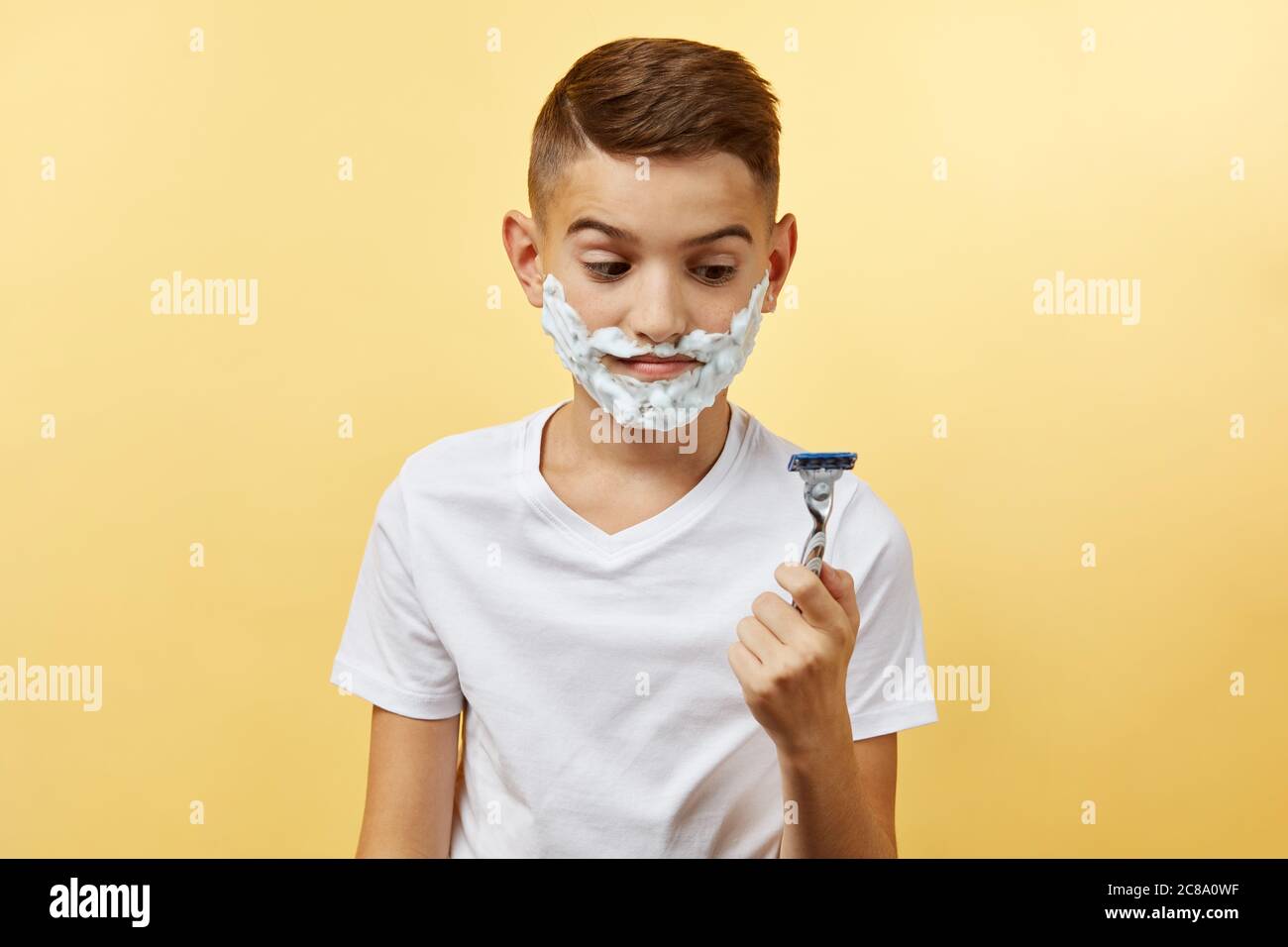 shoking boy do not know how shaving with razor blade in his hand, on ...