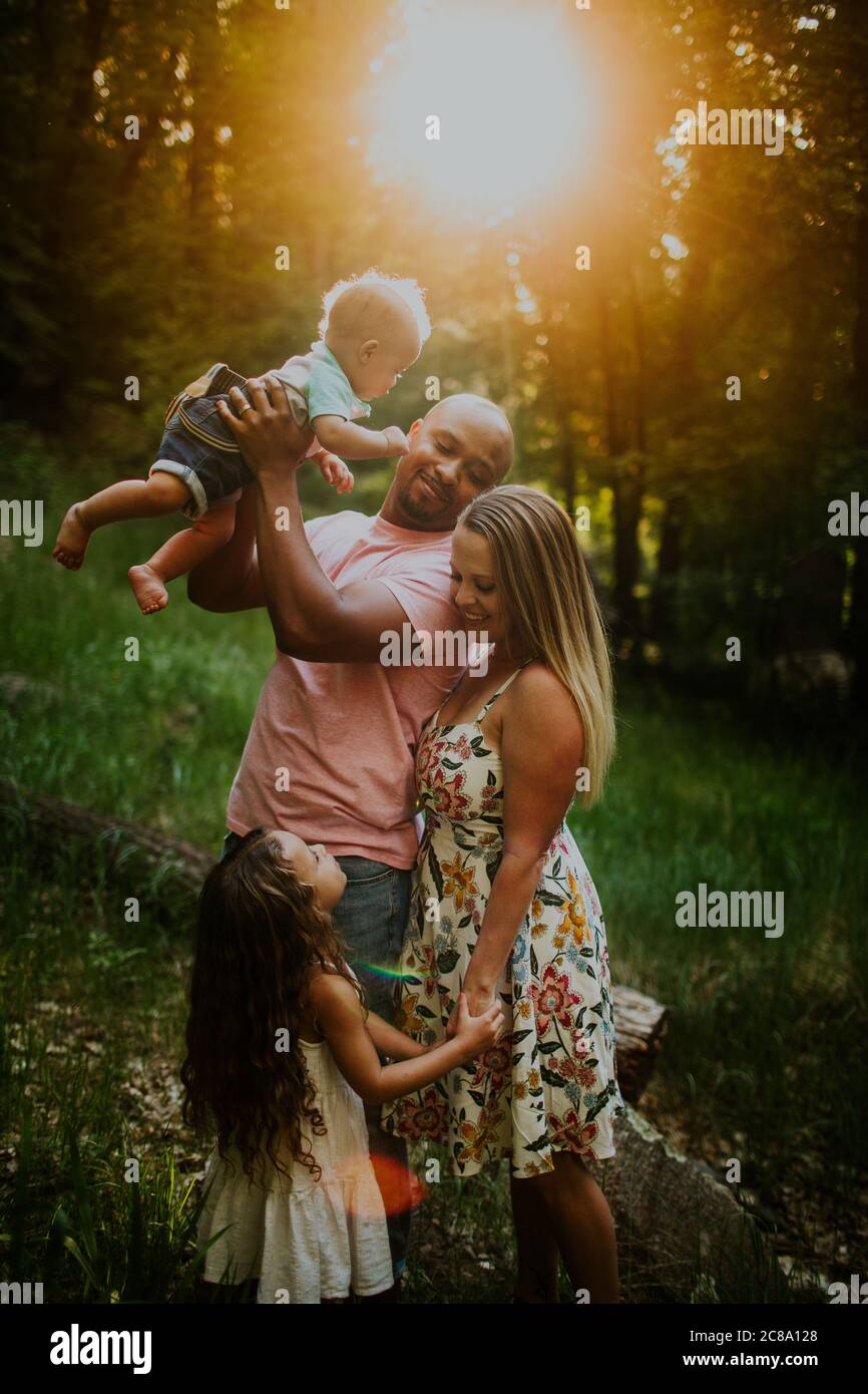 Vertical portrait of biracial family looking at each other Stock Photo ...