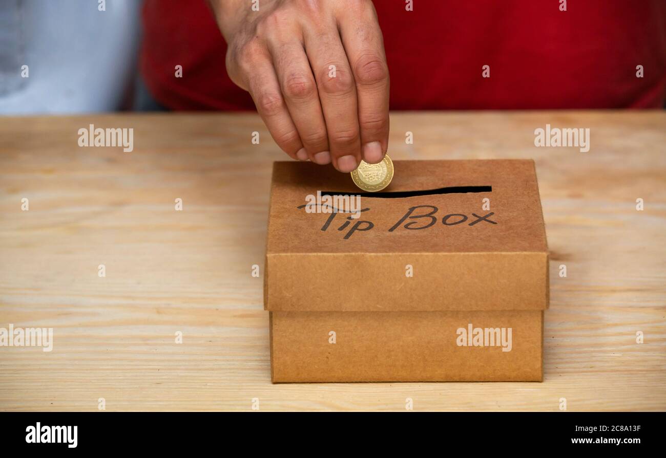 coins pooring into a tip box, selective focus Stock Photo - Alamy