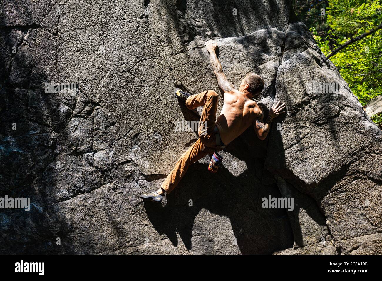 Climber using heel hook to get to the top of the boulder Stock Photo ...