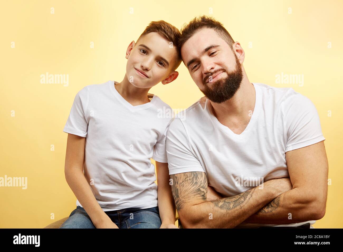 dad and son looking at camera on yellow background Stock Photo - Alamy