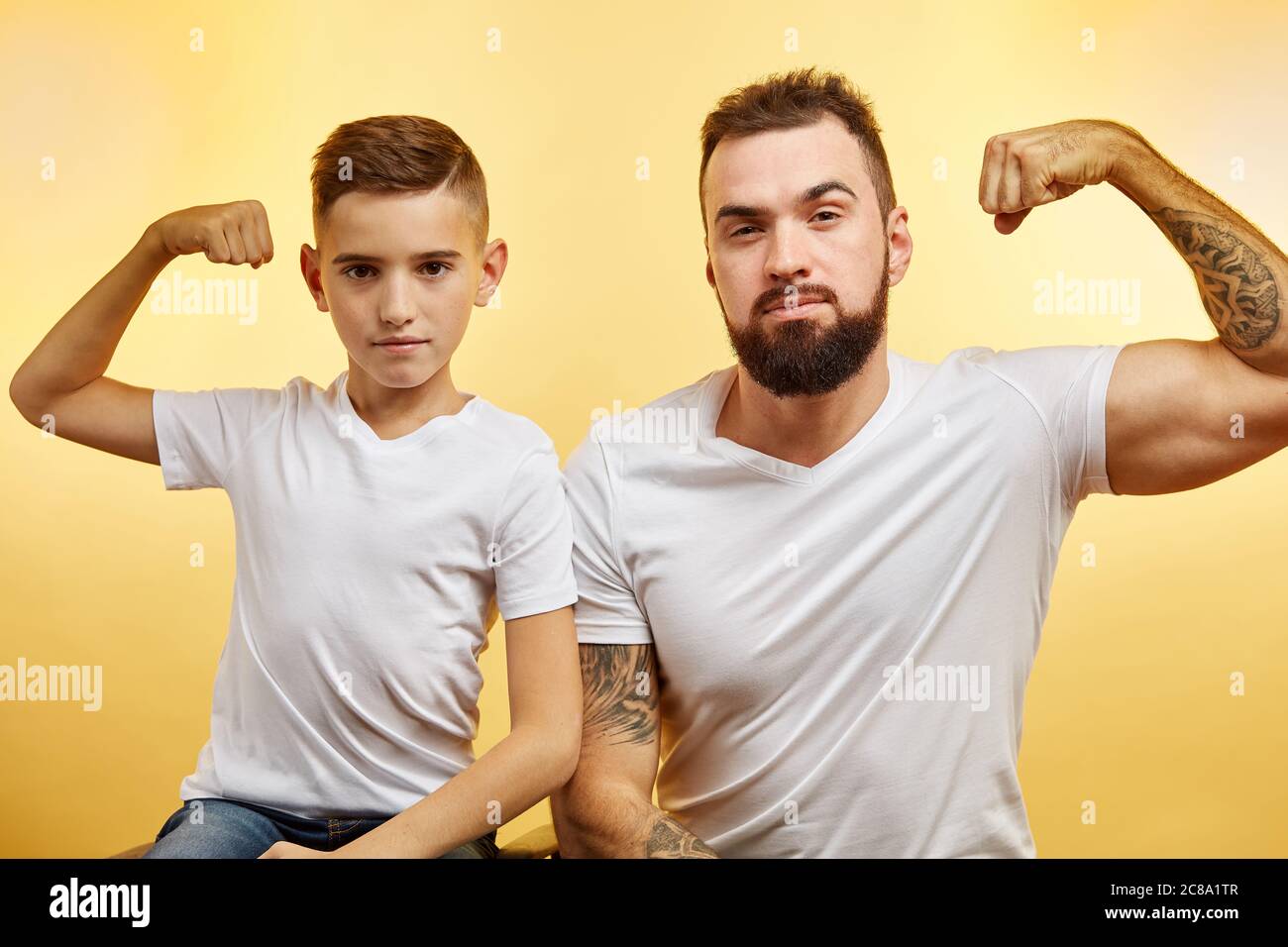 Handsome bearded father and his son looking at camera and smiling while ...