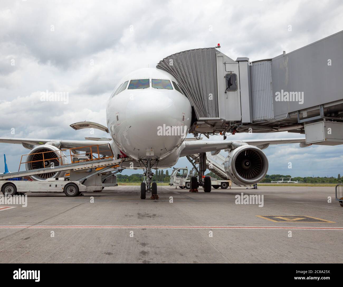 Passenger white plane at the airport. Boarding passengers through the ...