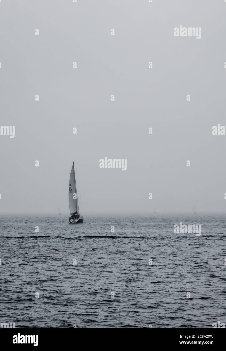 Boat in the fog sailing by the sea Stock Photo - Alamy